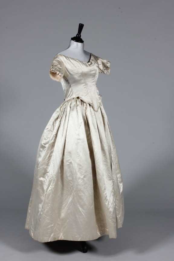 Lot 50 - An ivory satin bridal gown, circa 1845, with