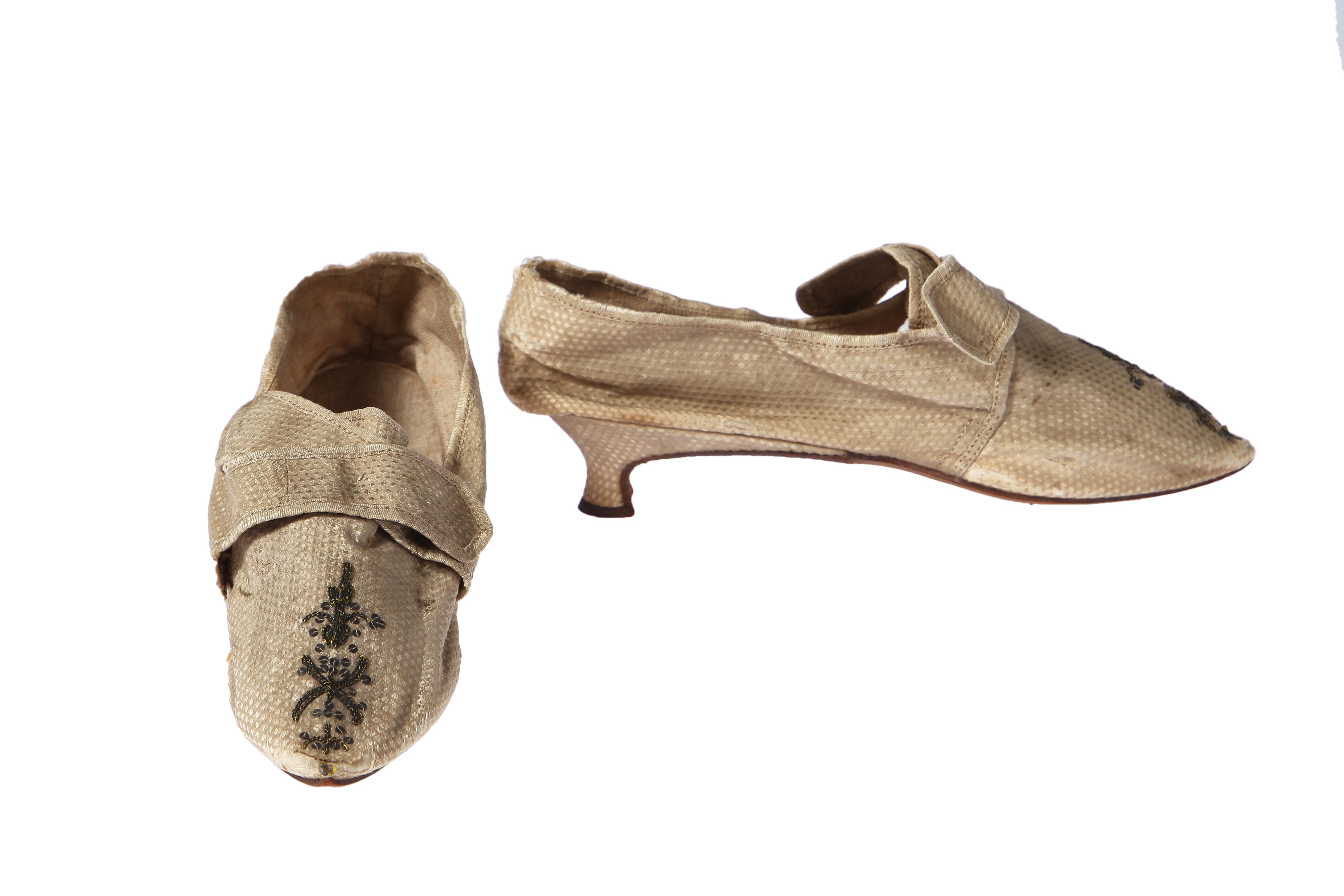 Lot 490 - A pair of ivory-figured silk shoes, circa